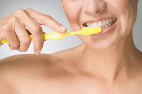 brushing your teeth with a toothbrush and toothpaste